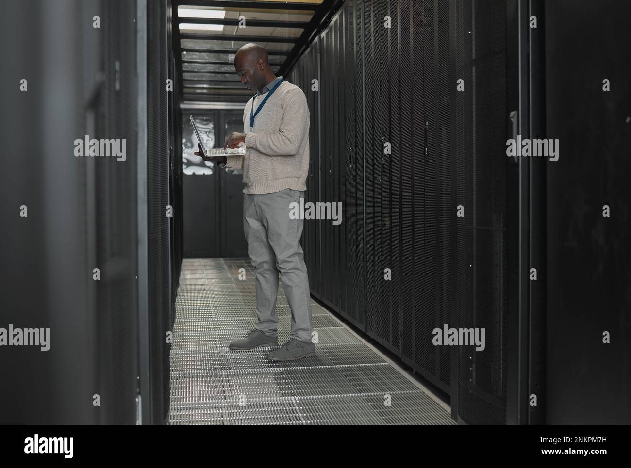 Server room, data center or IT black man with laptop for research ...