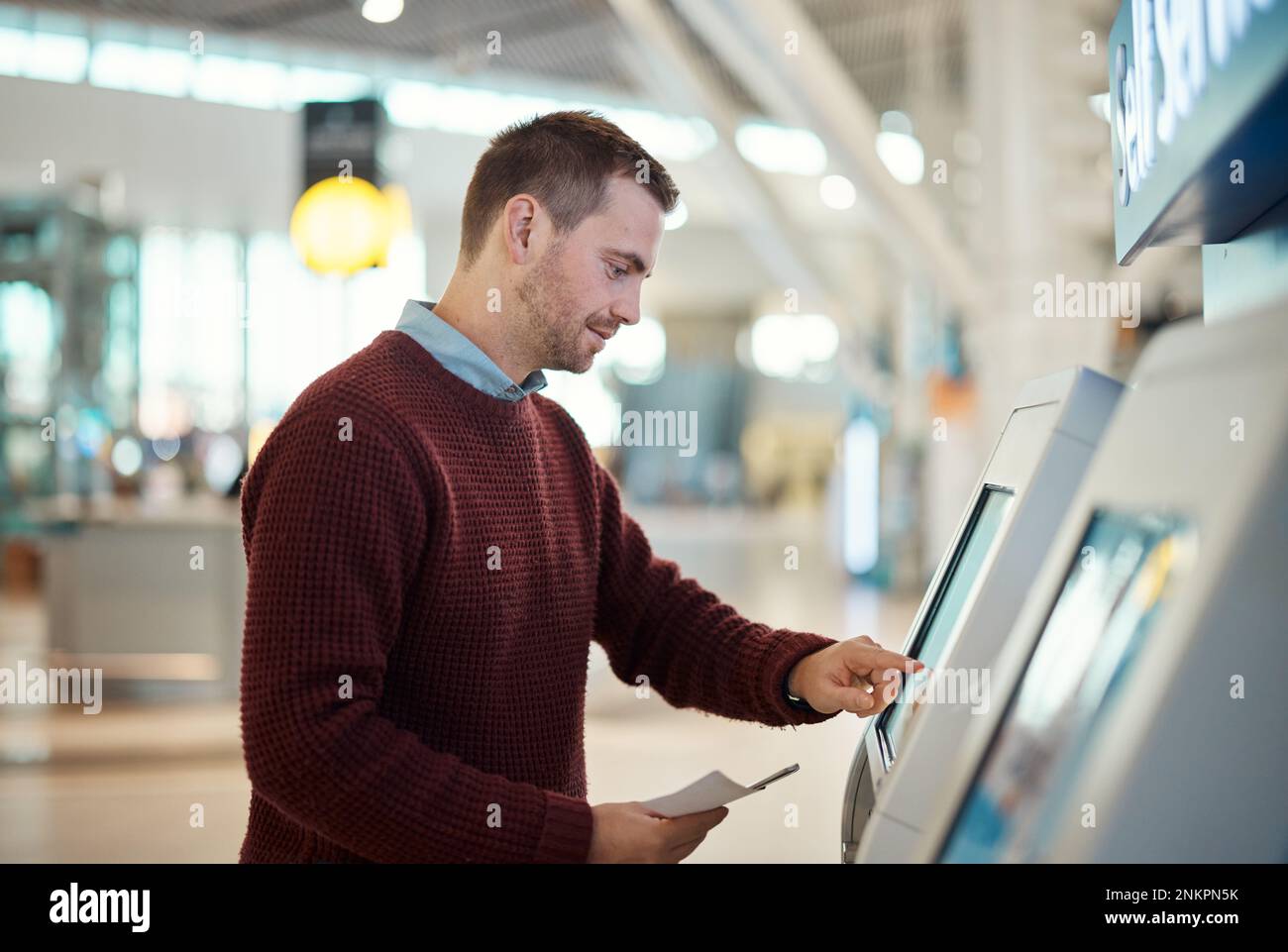 Man, airport and self service for check in, ticket registration or ...