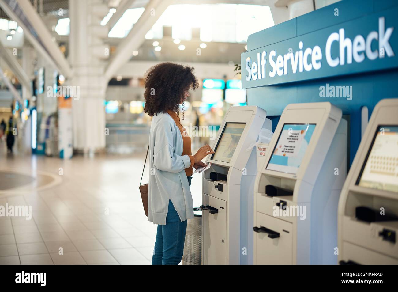 Black woman, airport and self service kiosk for check in, ticket ...