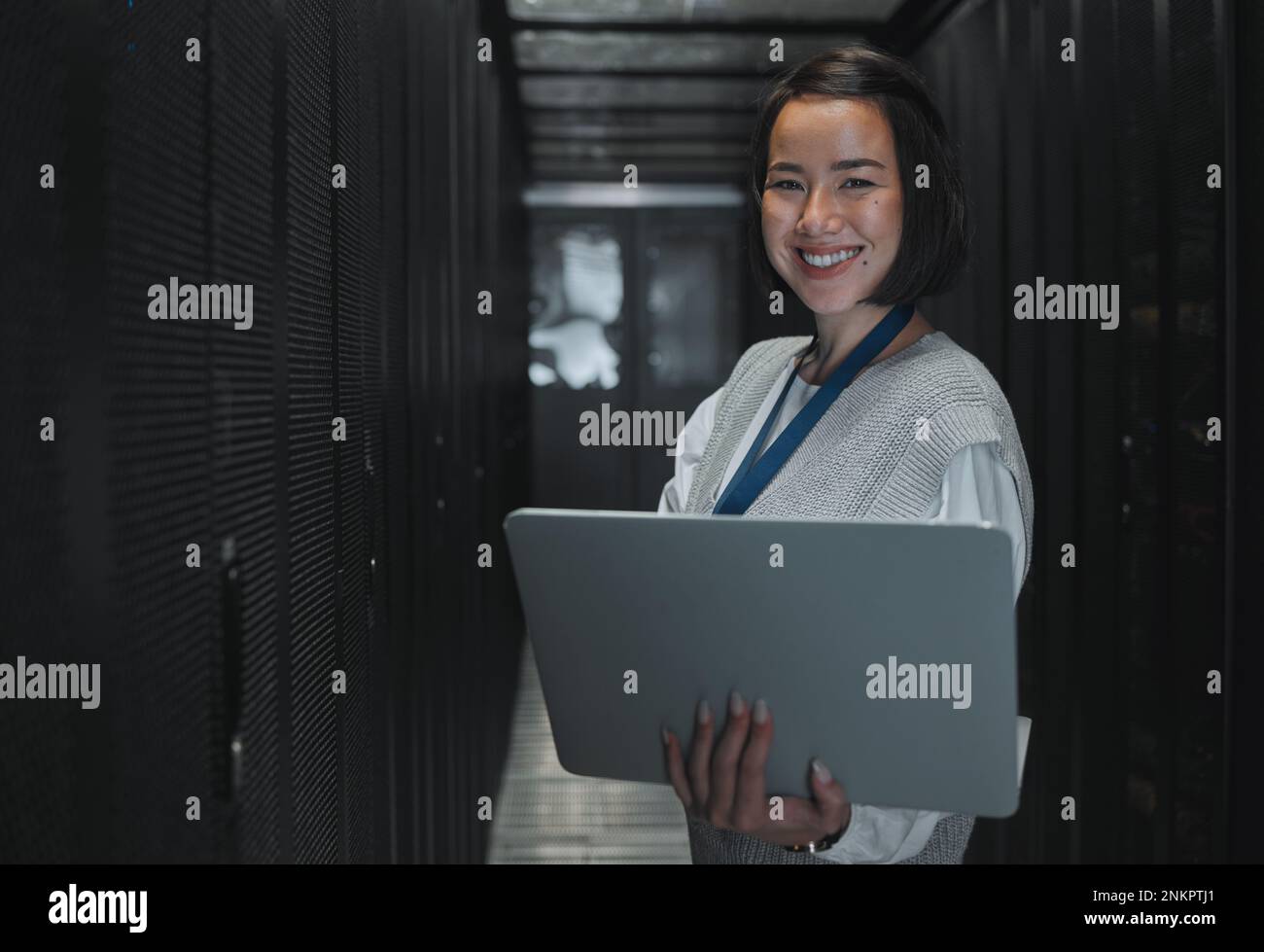 Woman with laptop, server room and information technology, smile in ...