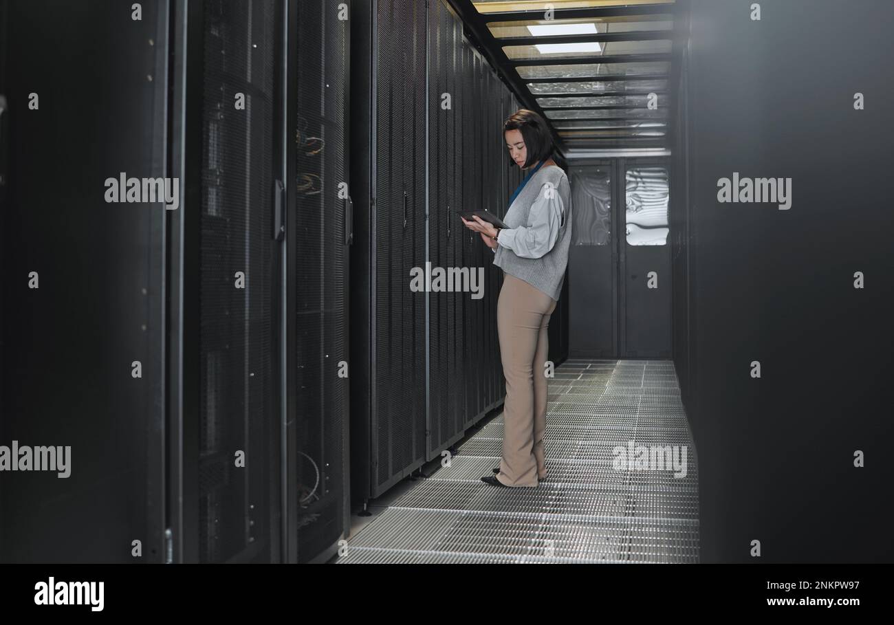 Tablet, server room and data center with a programmer asian woman at ...
