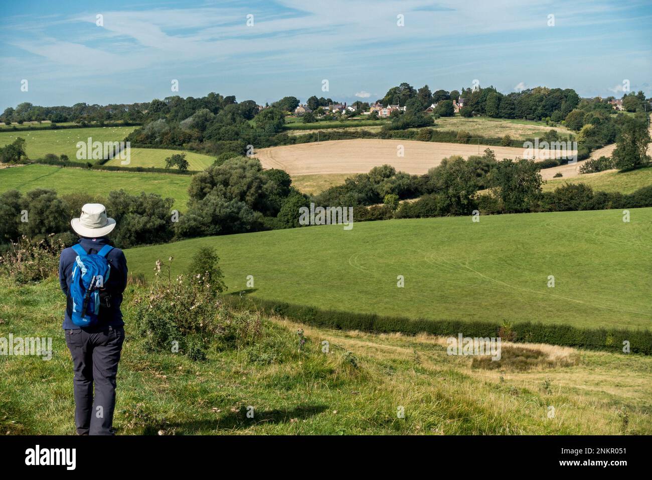 Rambler walking towards the hilltop village of Burrough on the Hill as ...