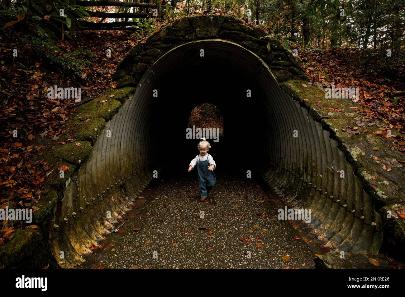 Young girl running through tunnel Stock Photo - Alamy