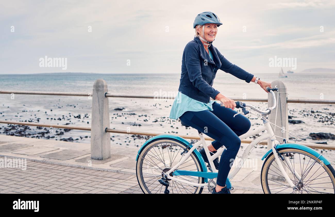 Happy, smile and cycling with old woman at beach for fitness, peace and ...