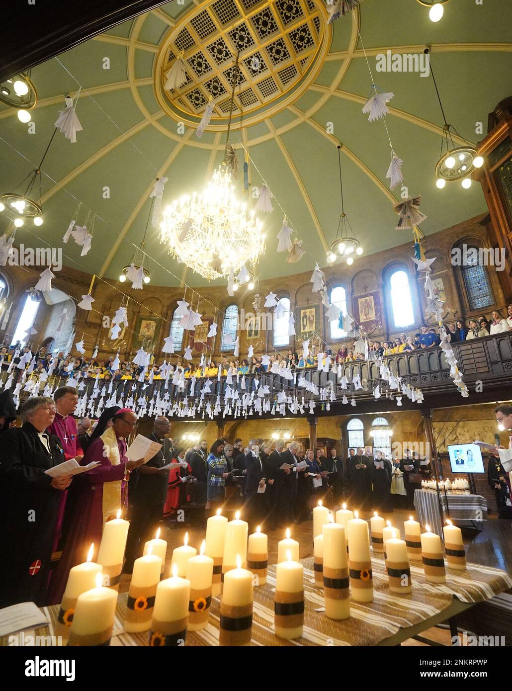 52 candles, one for each week of the war, beneath 461 paper angels, one ...