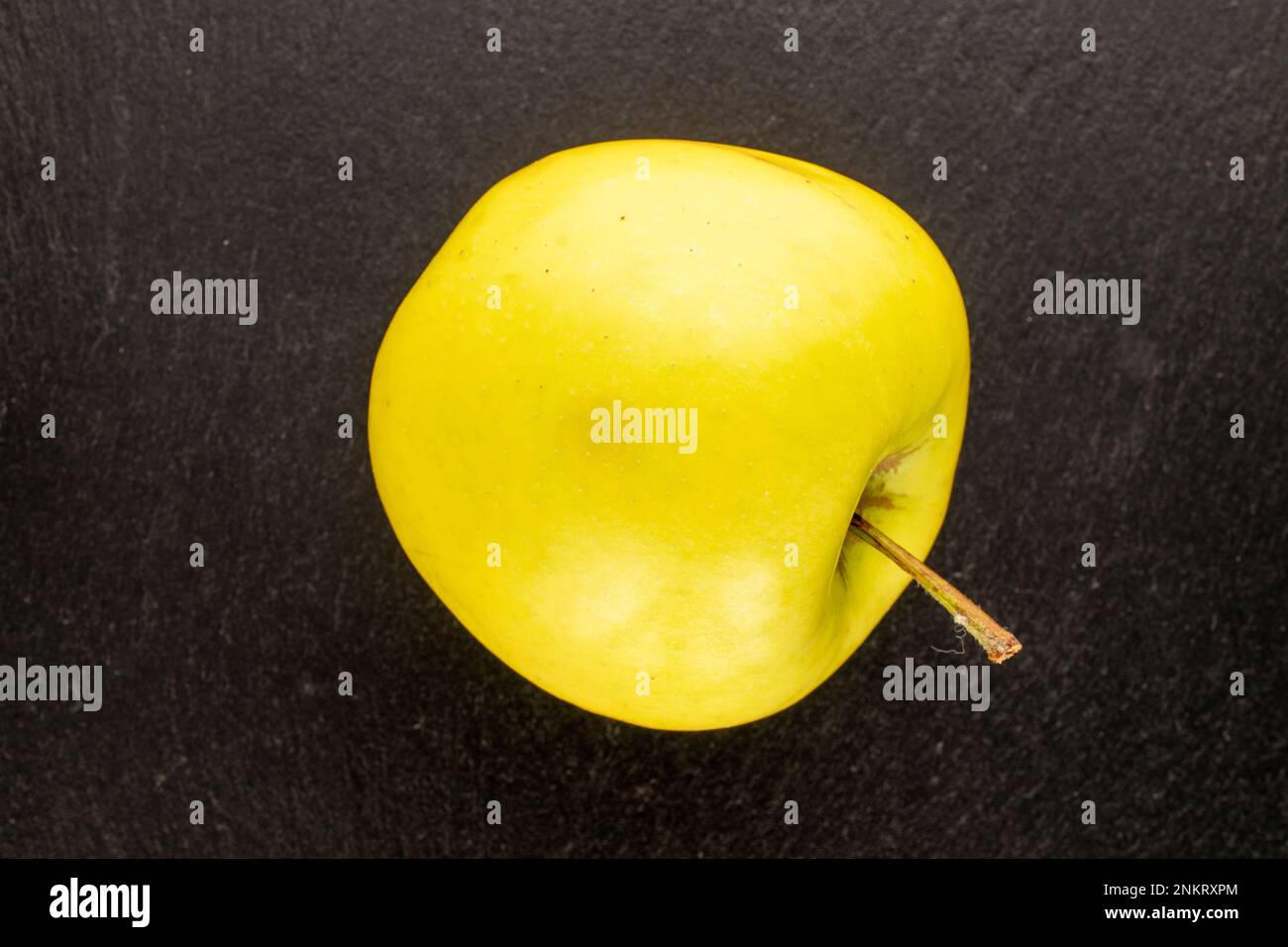 One yellow organic apple on slate stone, macro, top view Stock Photo ...