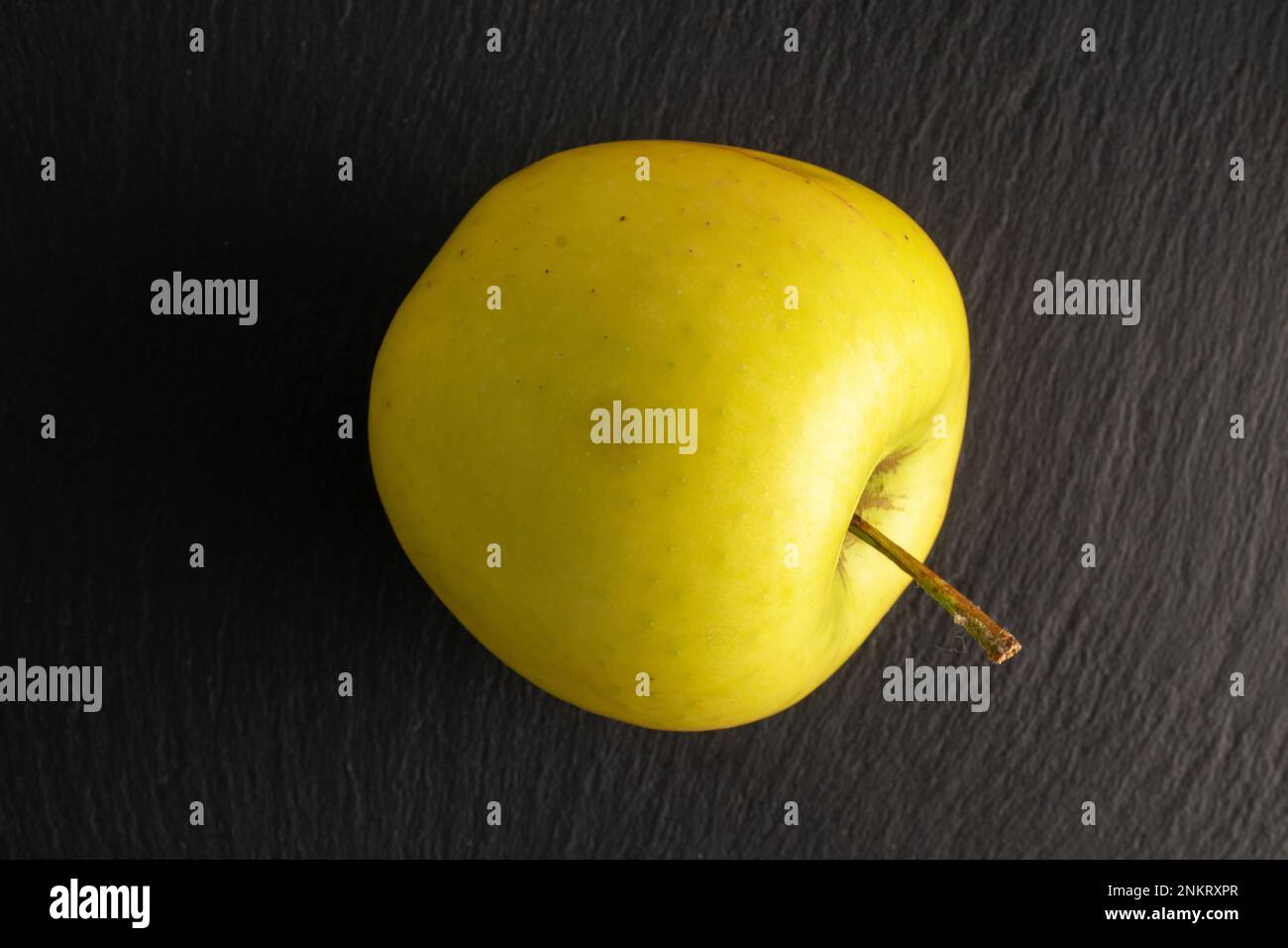 One yellow organic apple on slate stone, macro, top view Stock Photo ...