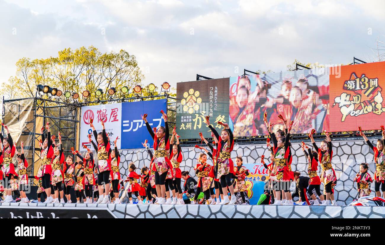 Japanese team of female children Yosakoi dancers dancing and holding ...