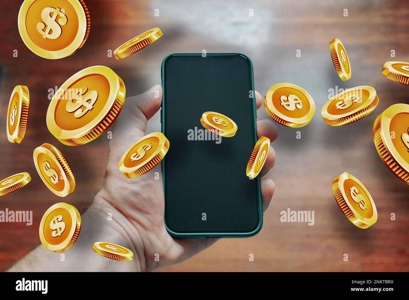 hand holding a phone with coins on the screen Stock Photo - Alamy