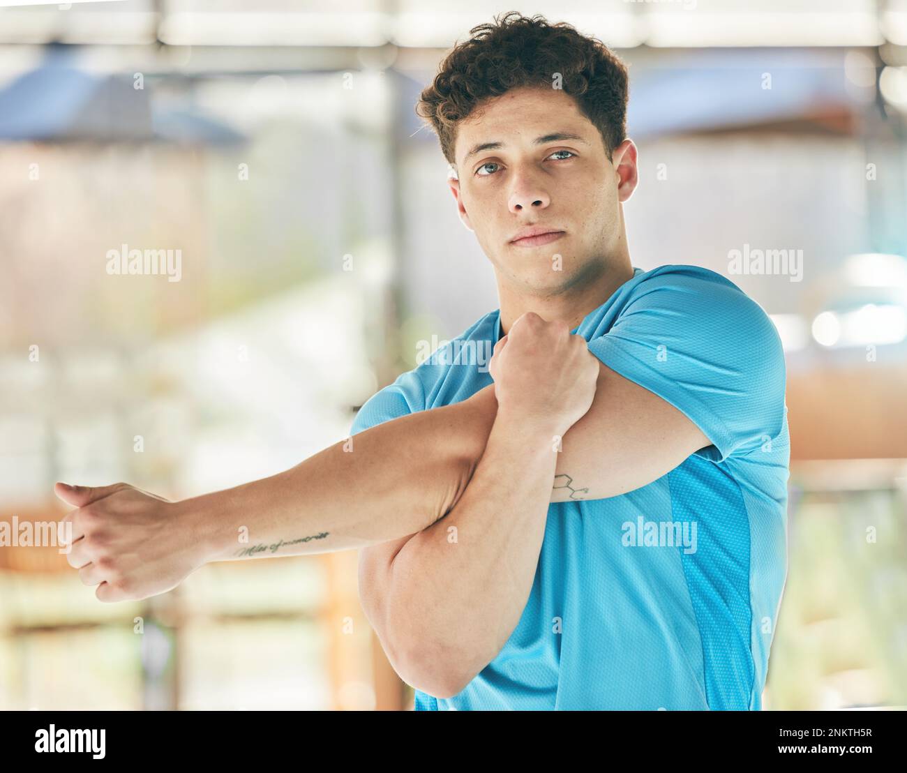 Portrait, fitness and man stretching arm in gym for health, wellness ...