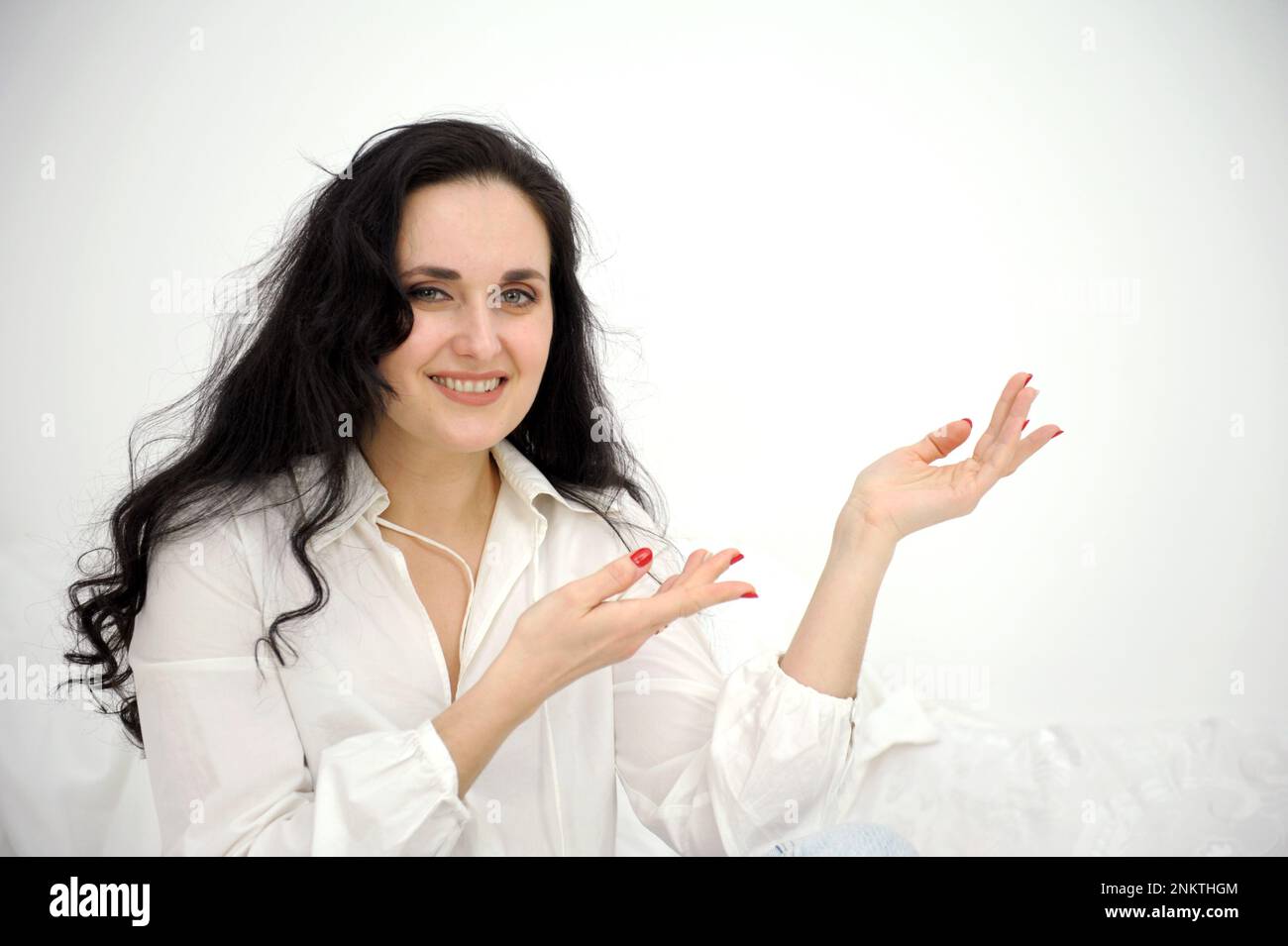 beautiful middle-aged woman shows hands on a white background empty ...