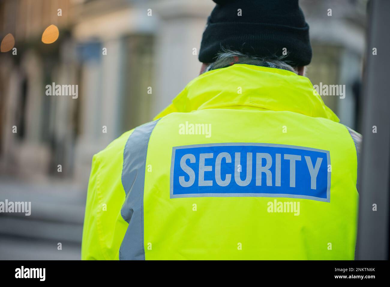 Security man looking away from the camera, wearing a brightly coloured ...
