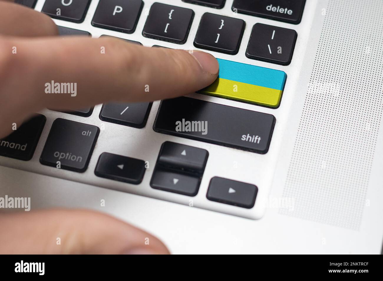 Pressing enter button with Ukraine flag, represents a cyber-attack of ...