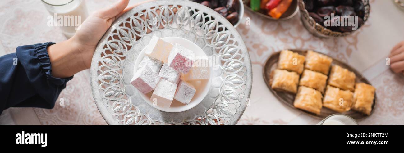 Top view of muslim woman holding plate with turkish delight during ...