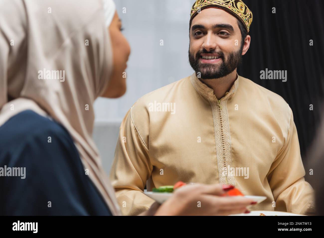 Positive muslim man looking at blurred wife with food at home,stock ...