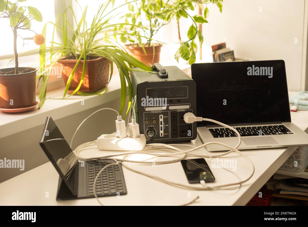 Portable power station charging tablet computer on table in living room ...