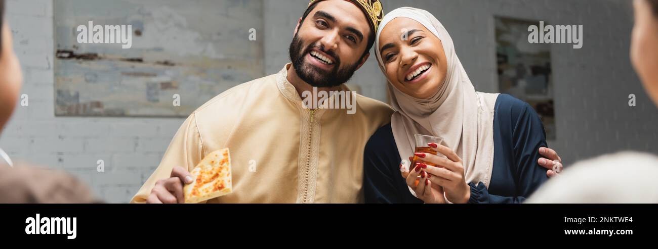 Cheerful muslim family hugging during ramadan dinner at home, banner ...