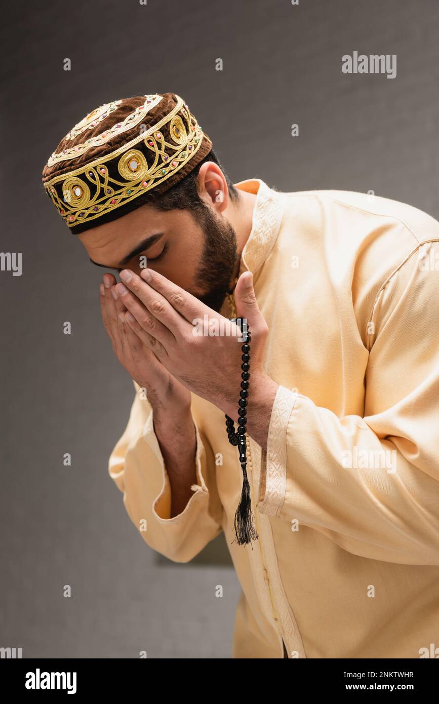 Young muslim man with prayer beads doing salah at home,stock image ...