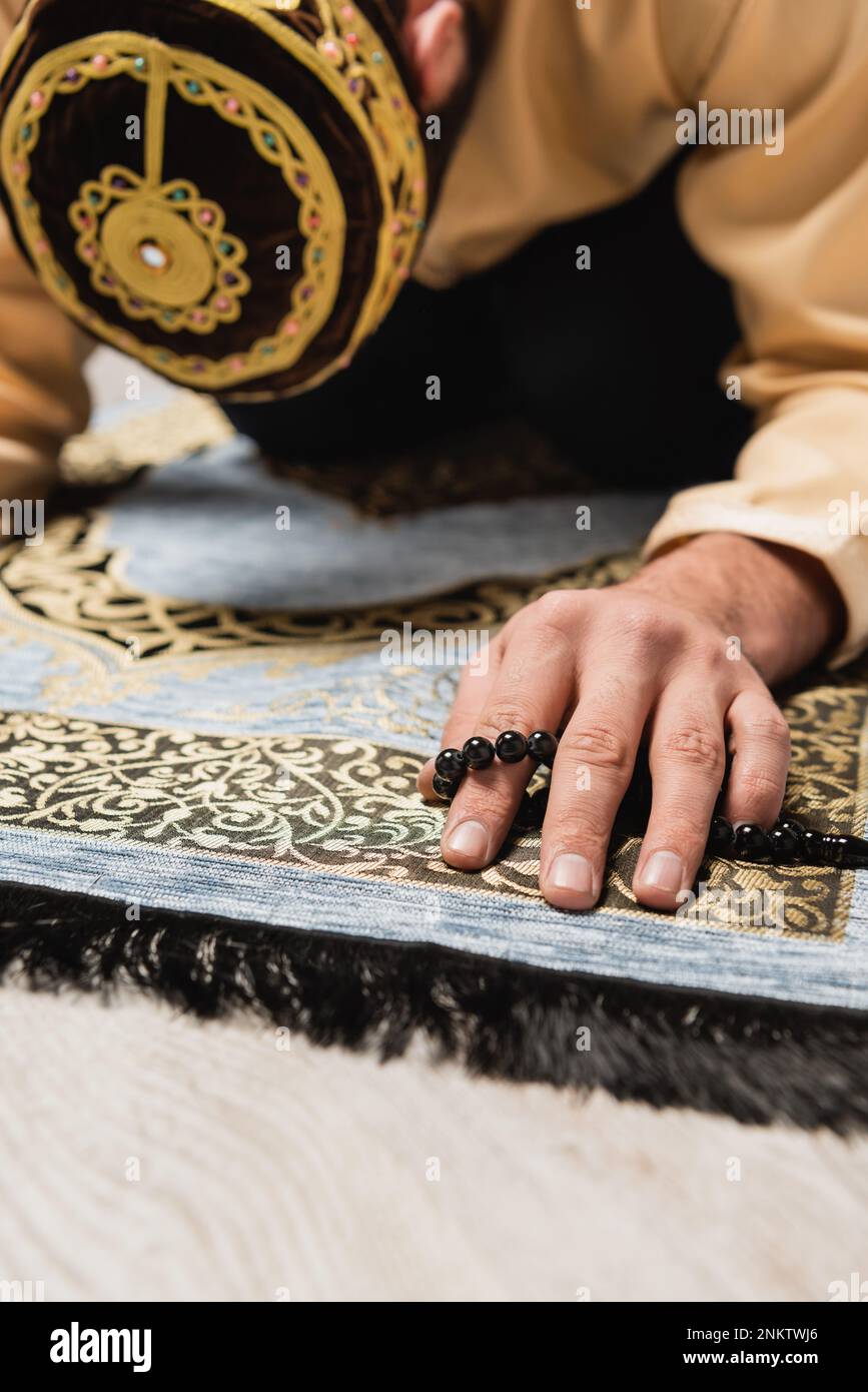 Blurred muslim man with prayer beads praying on carpet at home,stock ...