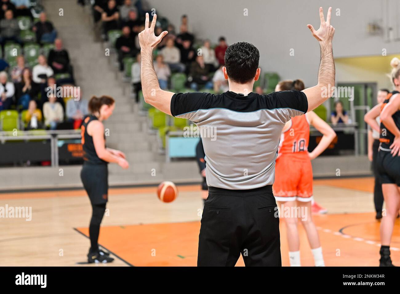 Man referee shows the free throw with his hands. In the background ...