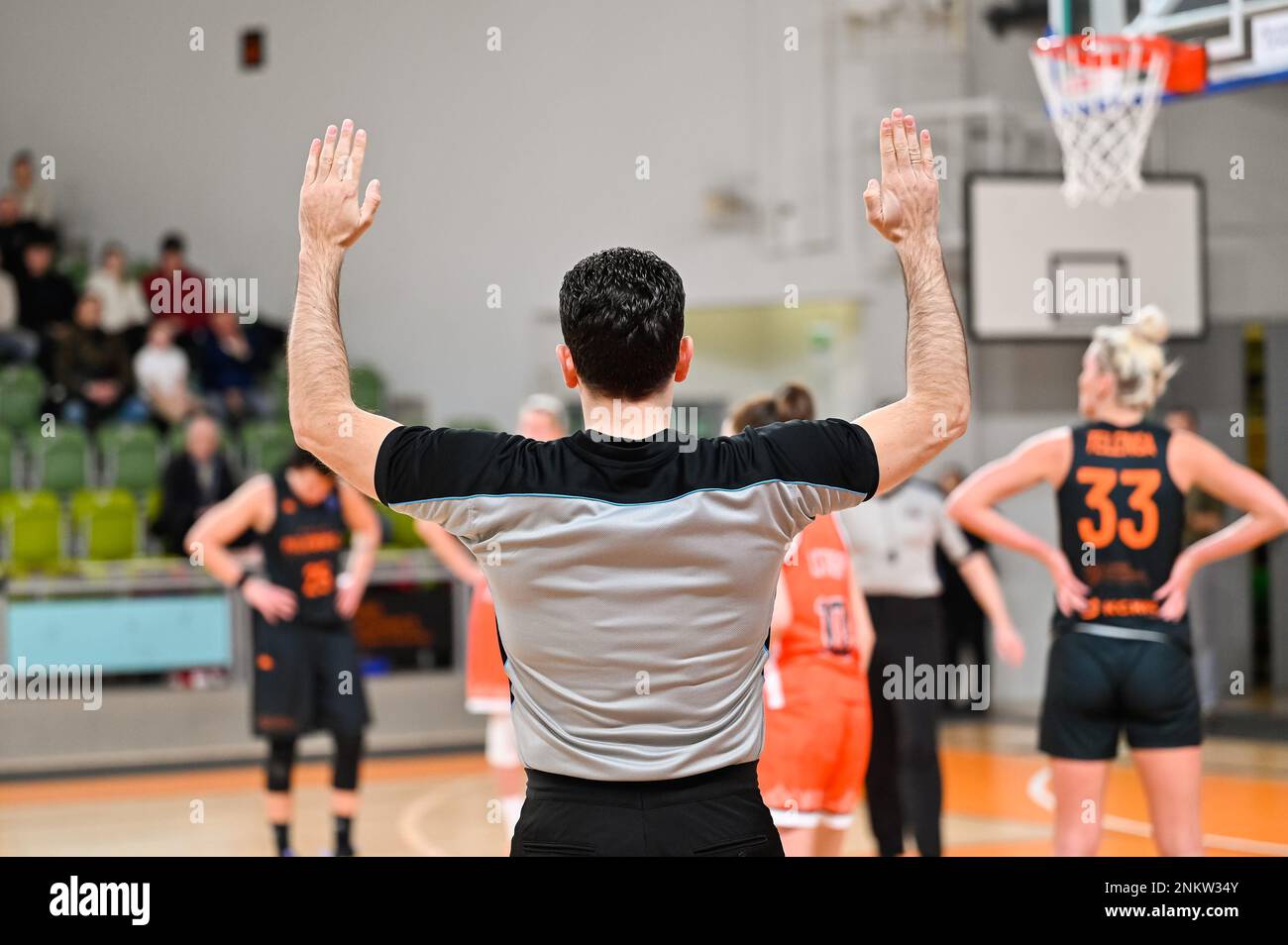 Man referee shows the free throw with his hands. In the background ...