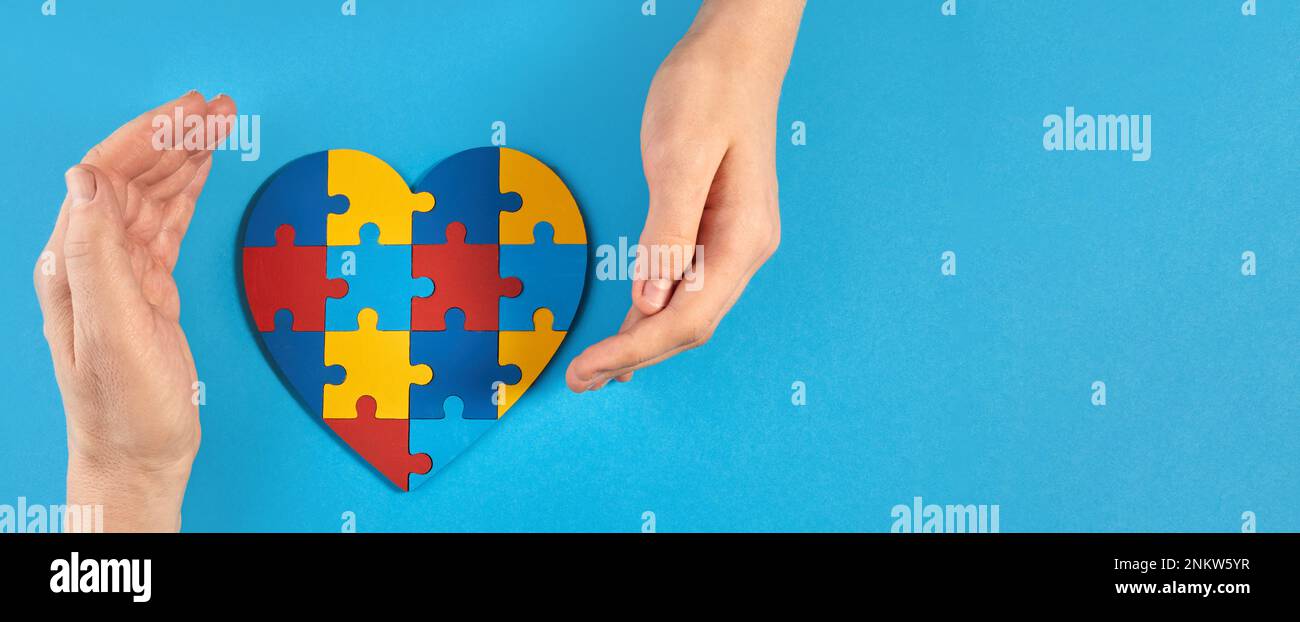 Father and autistic son hands holding jigsaw puzzle heart shape. World ...