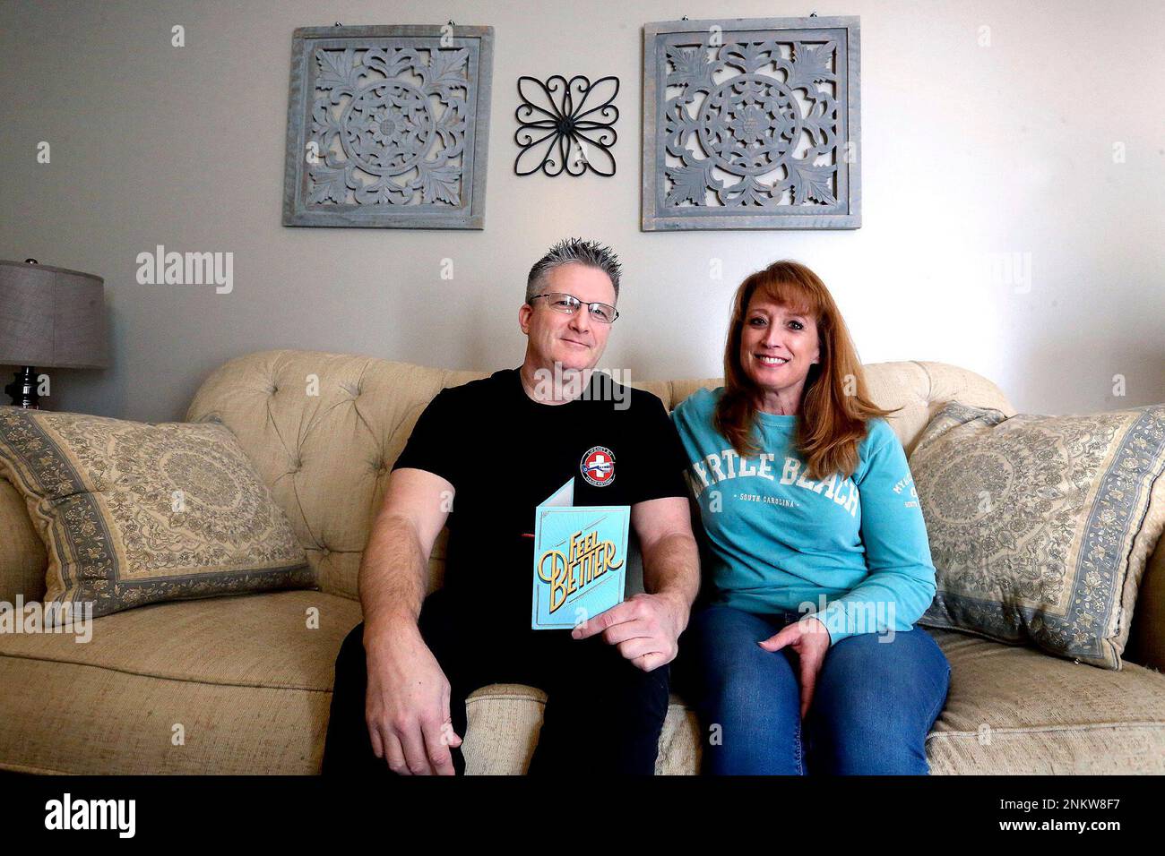 Helicopter pilot Danial Moore holds a get well card as he sits with ...
