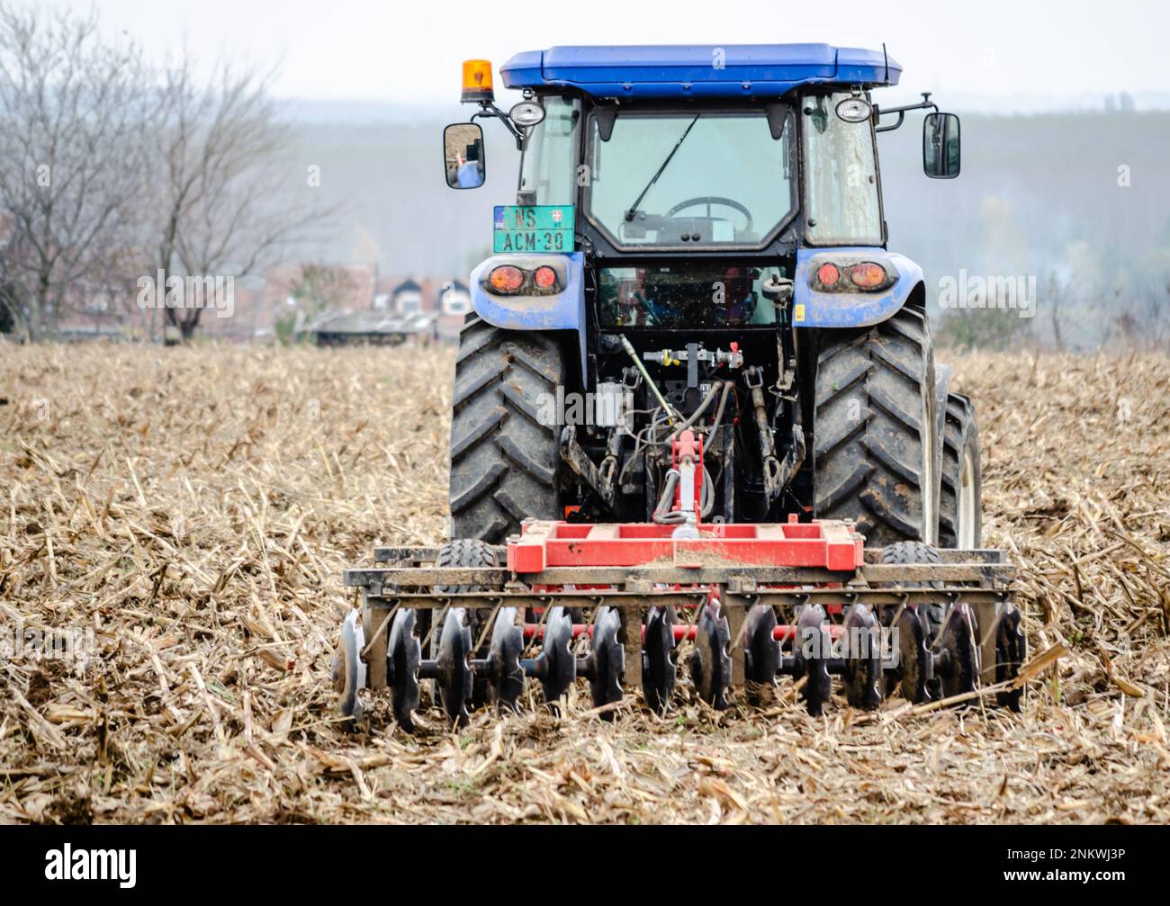 A large tractor driving through a farm field, transporting seedlings ...