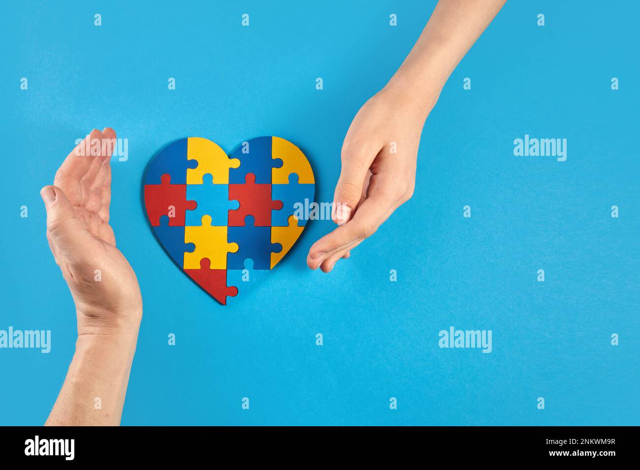 Father and autistic son hands holding jigsaw puzzle heart shape. World ...