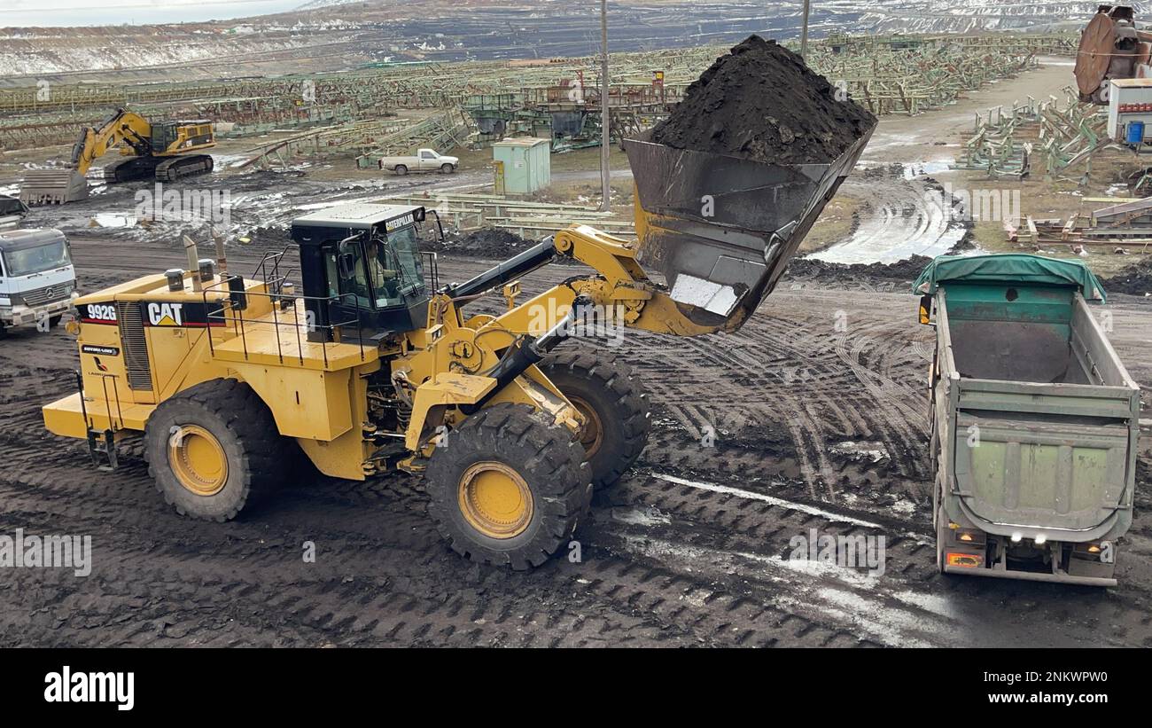 Huge Wheel Loader Loading Coal On Trucks, Coal Mine Stock Photo - Alamy