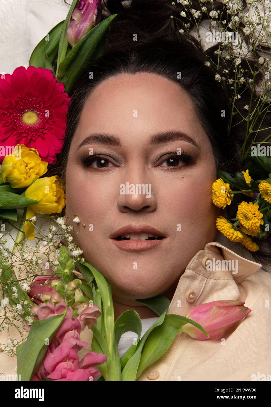 Portrait of a woman with spring flowers around her face, fresh ...