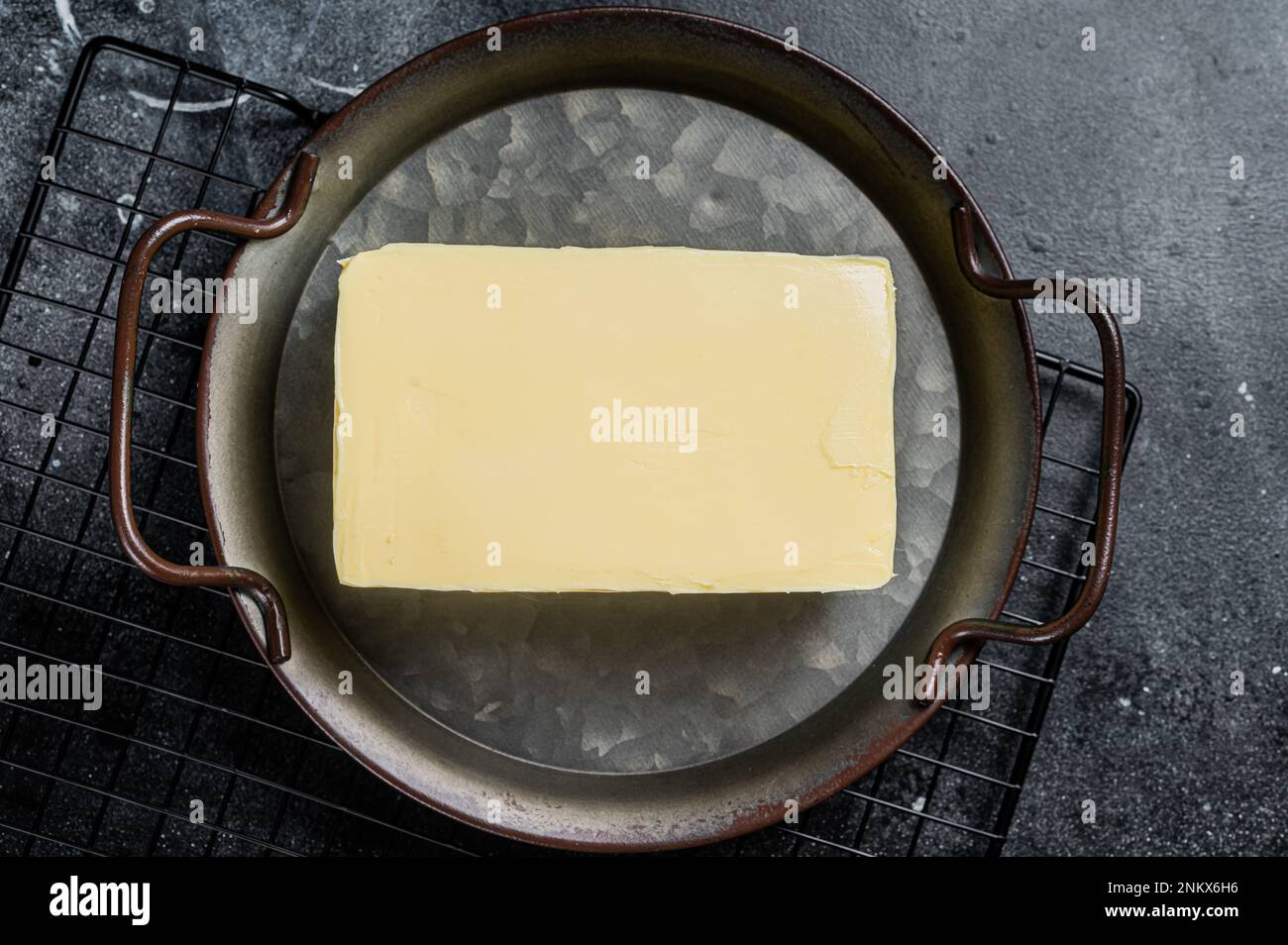 Butter block in steel kitchen tray. Black background. Top view Stock ...