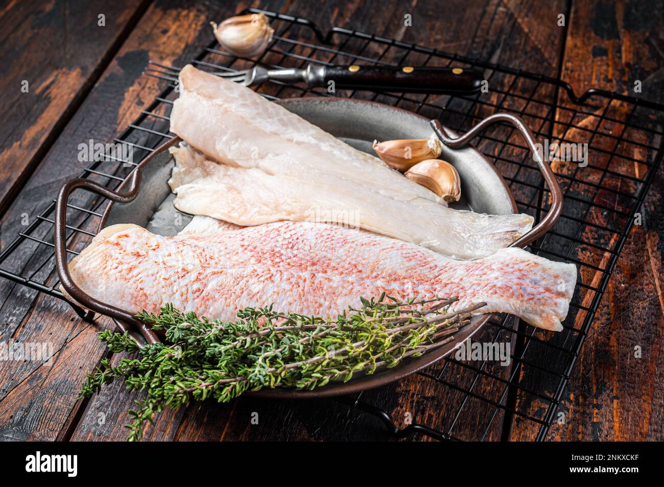 Raw red perch fillet, redfish fish meat in a steel tray. Wooden ...