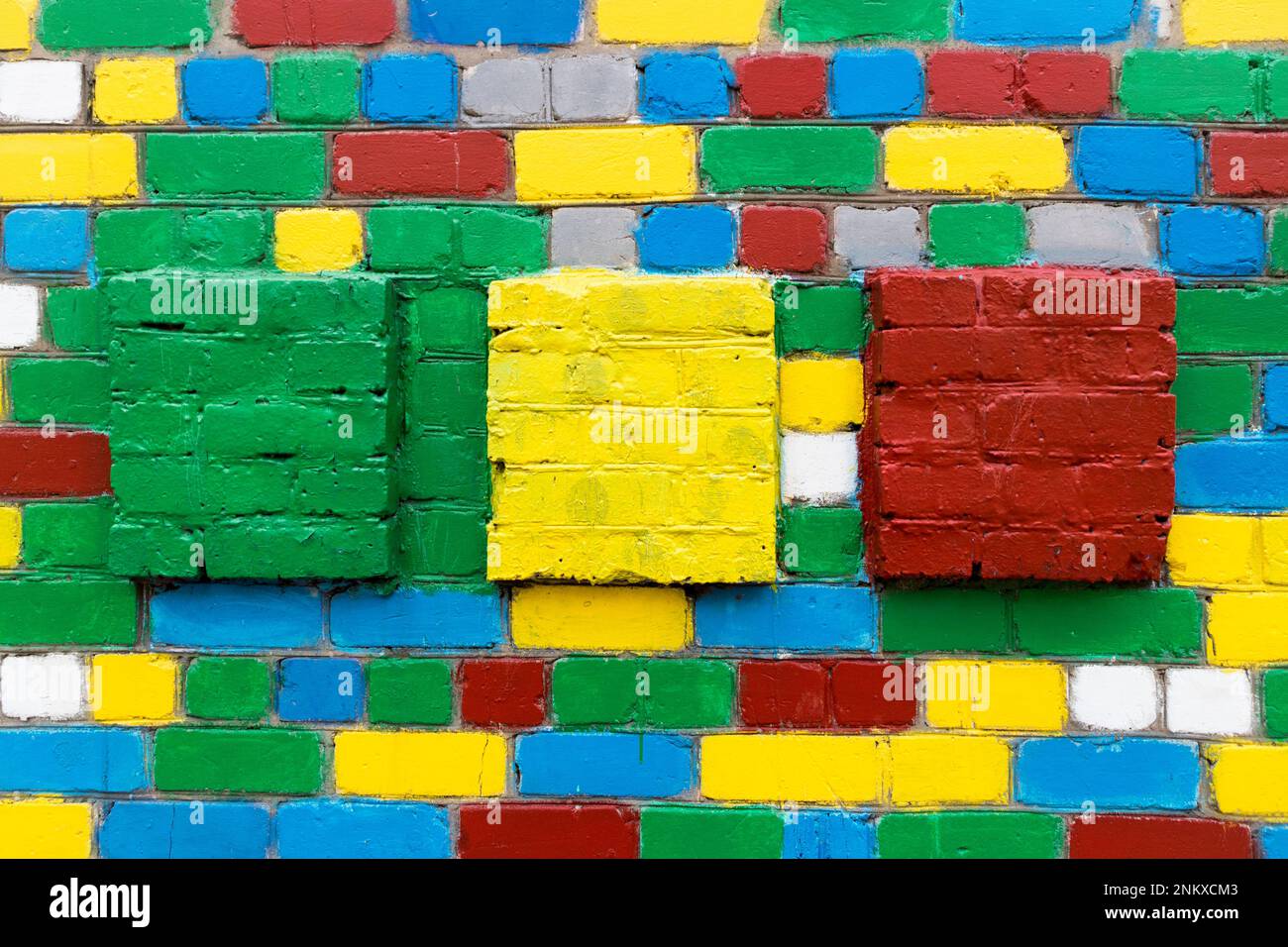 Brick wall with painted white, grey, blue, green, red, yellow bricks ...