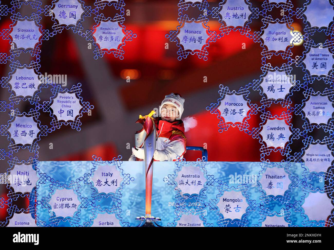 Zhang Junying carrying a torch lights a cauldron outside the National ...