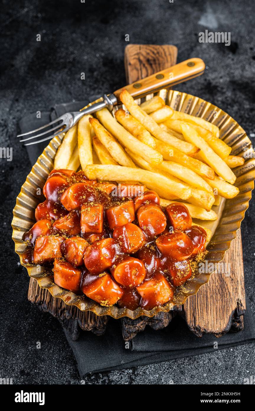 German currywurst with french fry served in a steel plate. Black ...