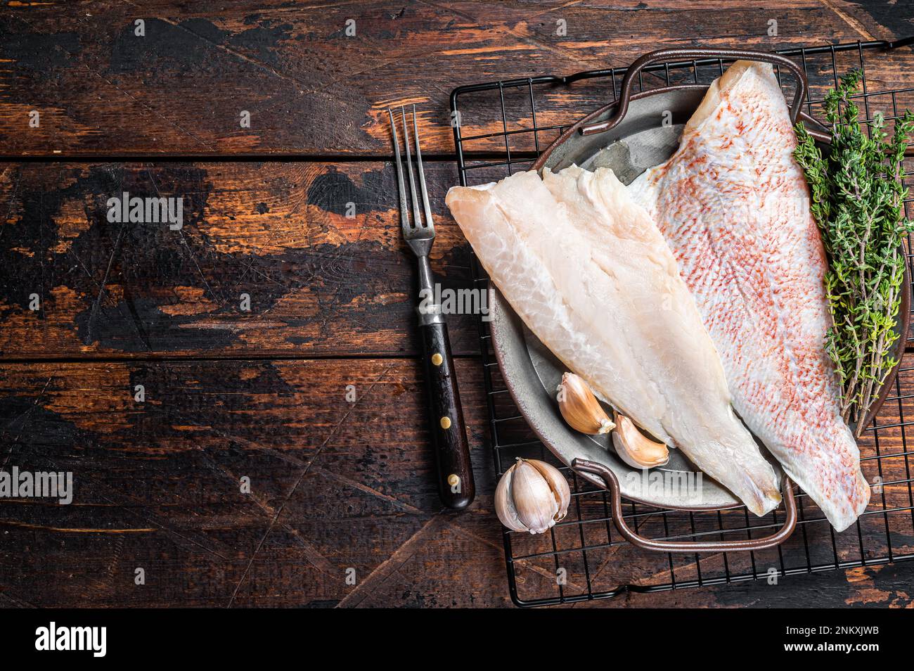 Raw red perch fillet, redfish fish meat in a steel tray. Wooden ...
