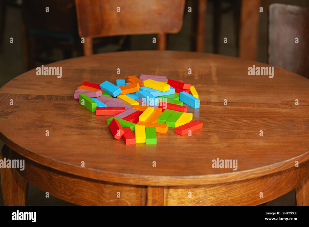 The ruined tower of Jenga game. Colored blocks scattered on table ...
