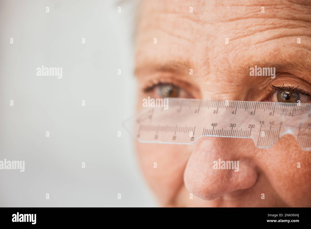 Ophthalmology, ruler and measuring with eyes of old woman for ...