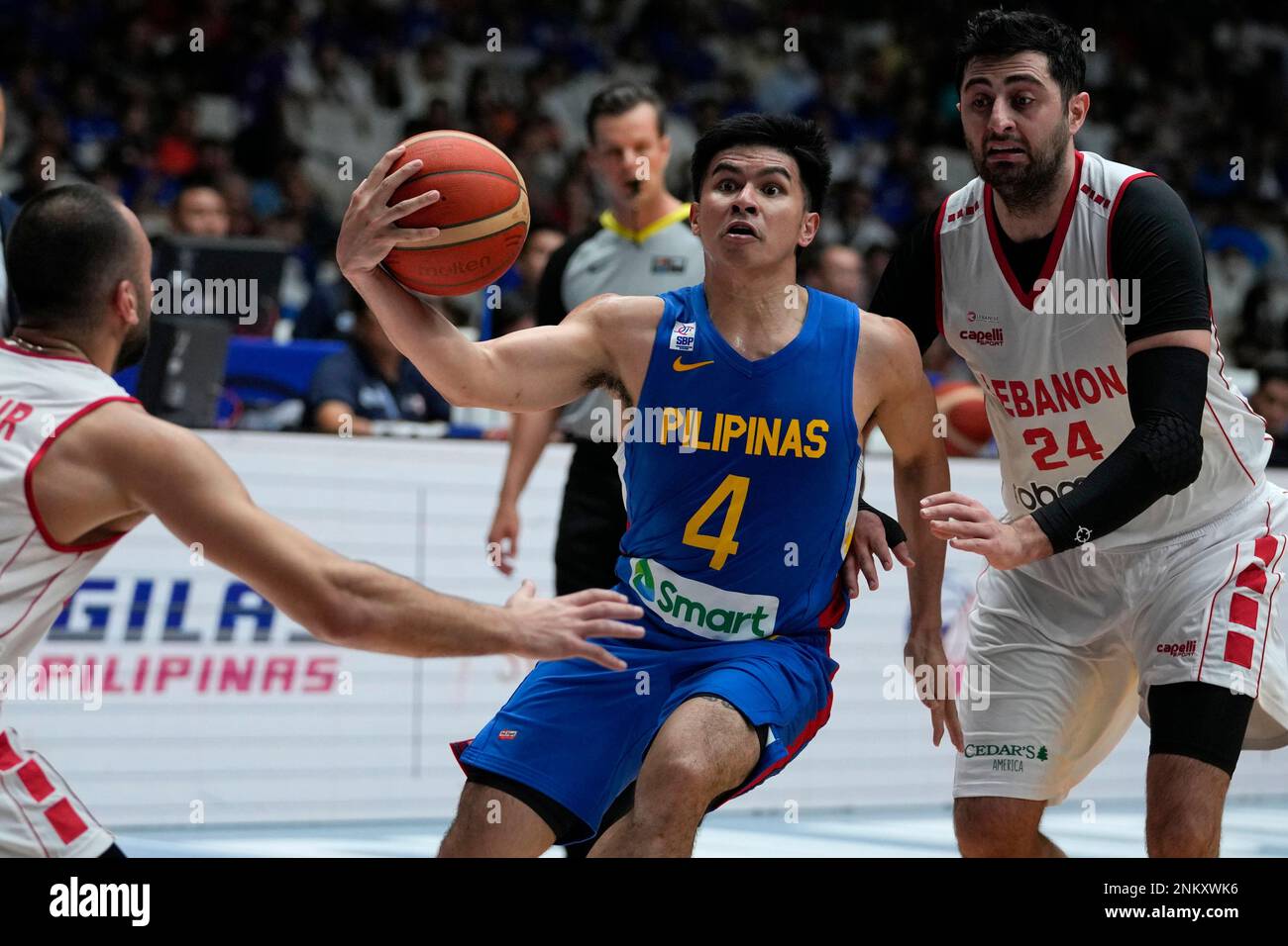 Philippines' Kiefer Ravena, center, drives past Lebanon's Hayk ...