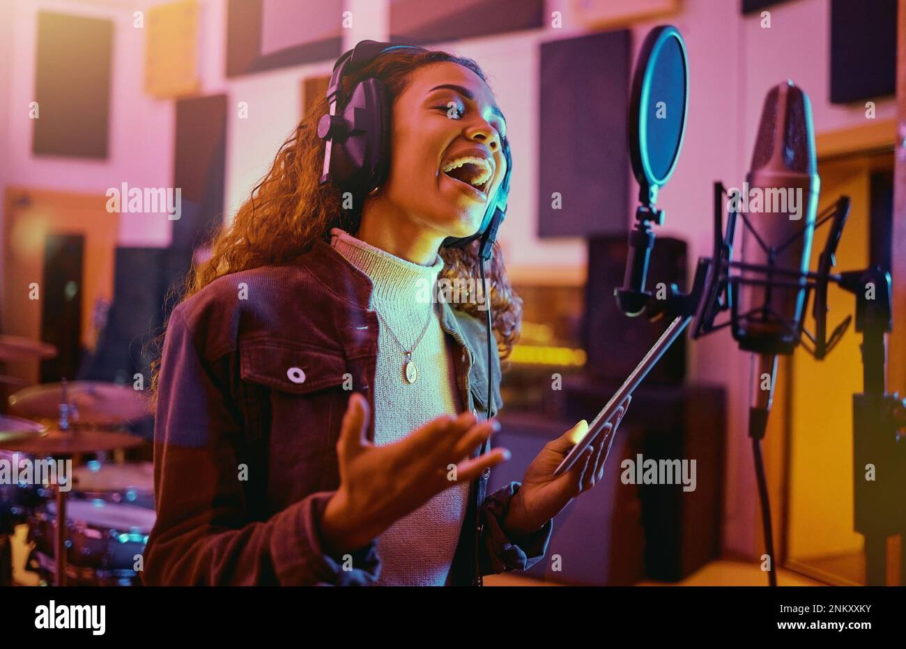 Tablet, music and woman singing in a studio for radio, song production ...