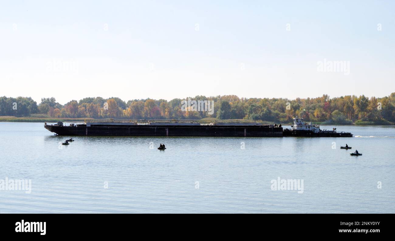 Barge with tugboat sailing along the river on the background of the ...