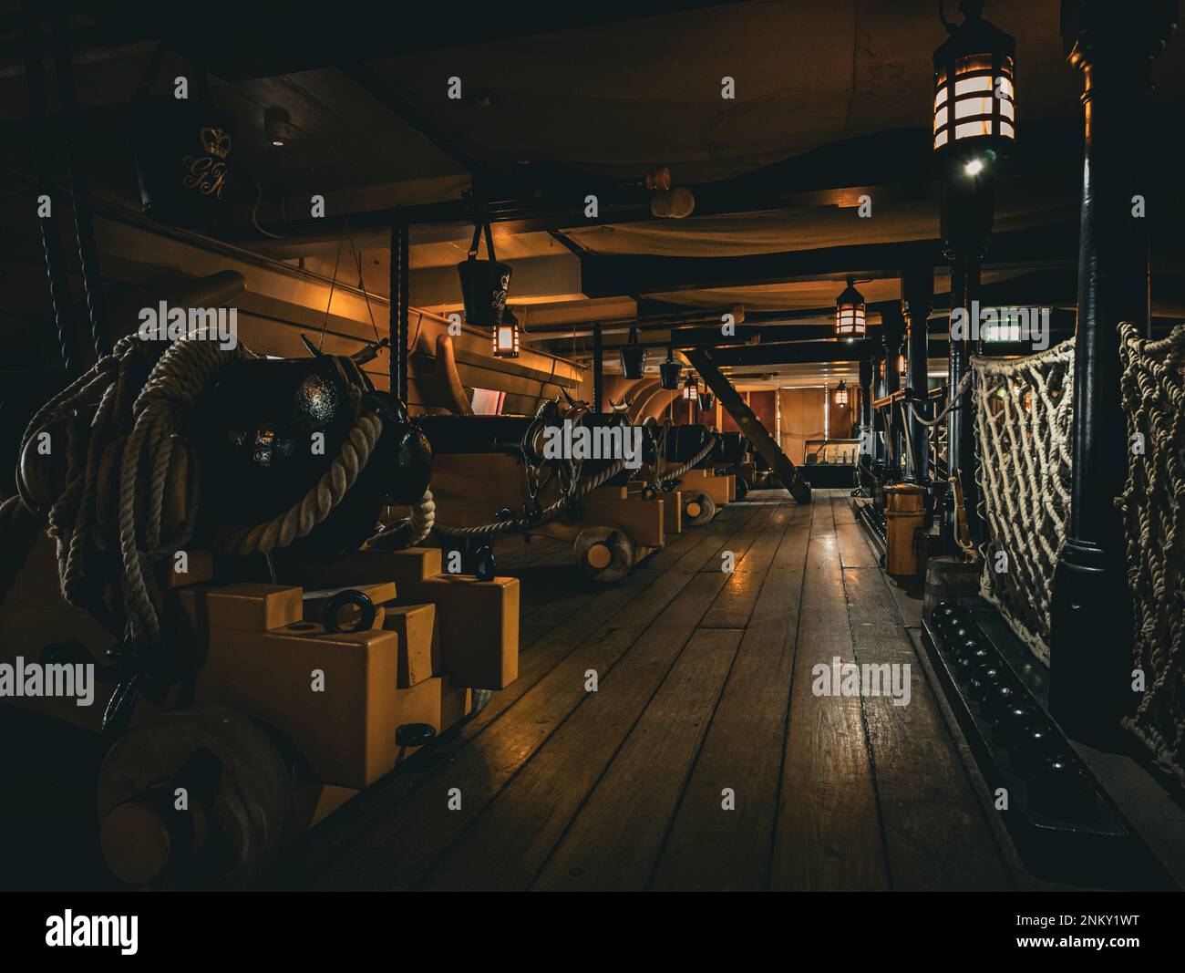 Inside the hull of HMS Victory. Some dim lights light the ancient ...