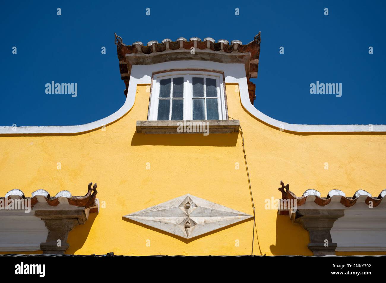 A yellow painted building with a white window in Lagos Algarve Portugal ...