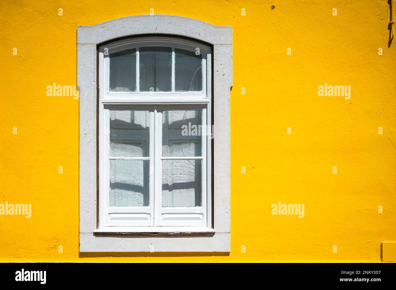 A yellow painted building with a white window in Lagos Algarve Portugal ...