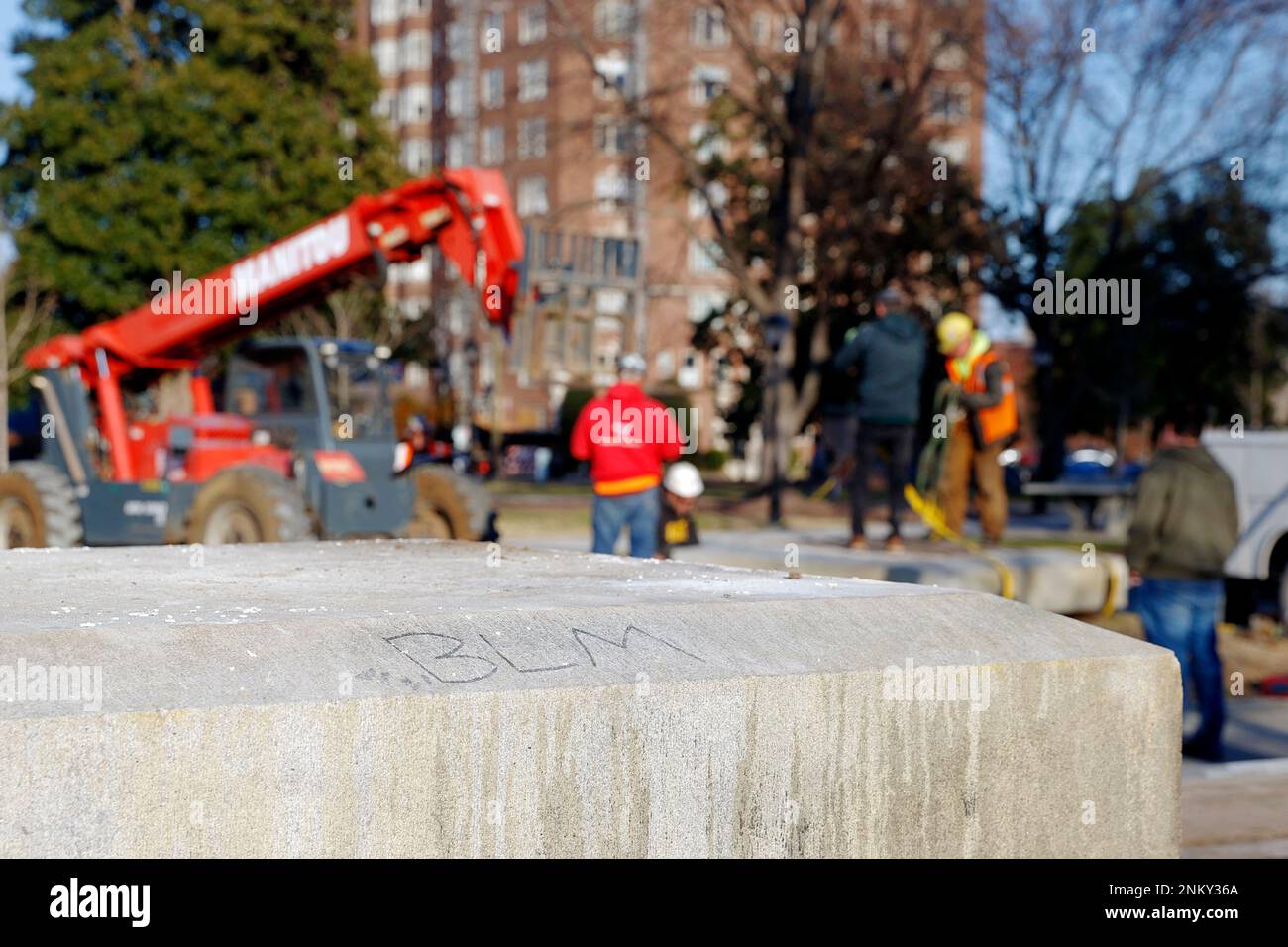 Workers remove the pedestal that once held the statue of Confederate ...