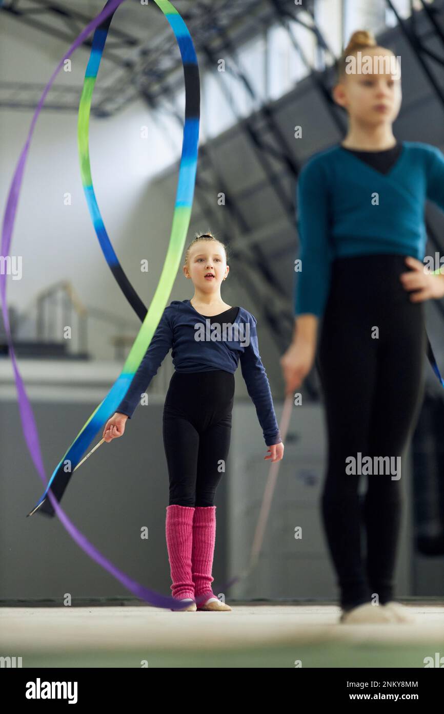 Little girls, children, rhythmic gymnasts training indoors, doing ...
