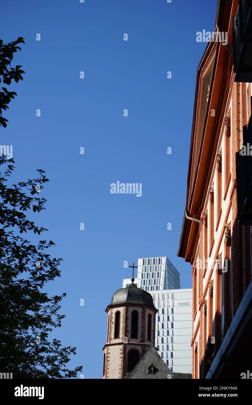 Two large buildings standing side by side with a tall tower and clock ...