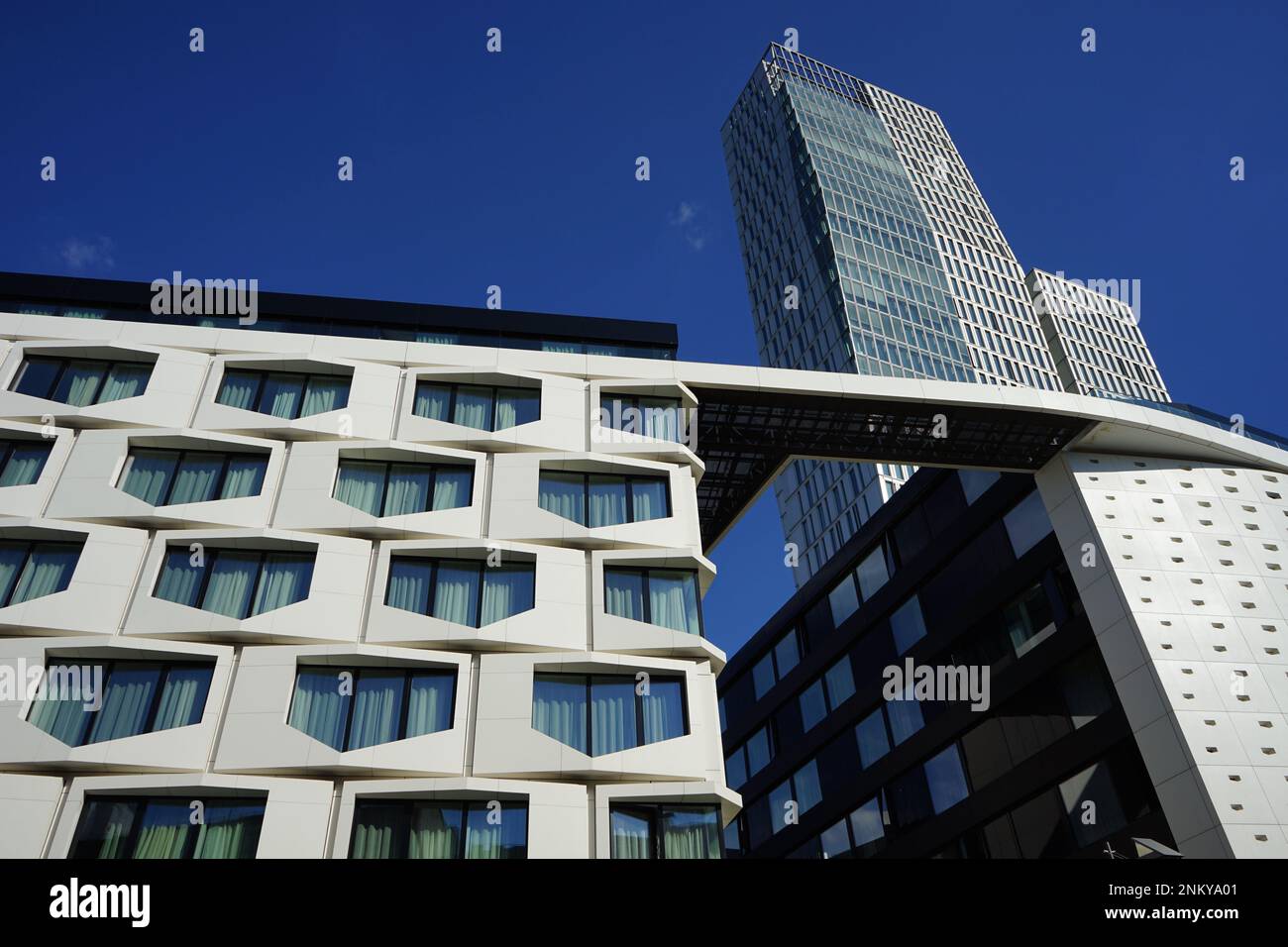 Two modern skyscraper buildings stand side-by-side in a bustling ...
