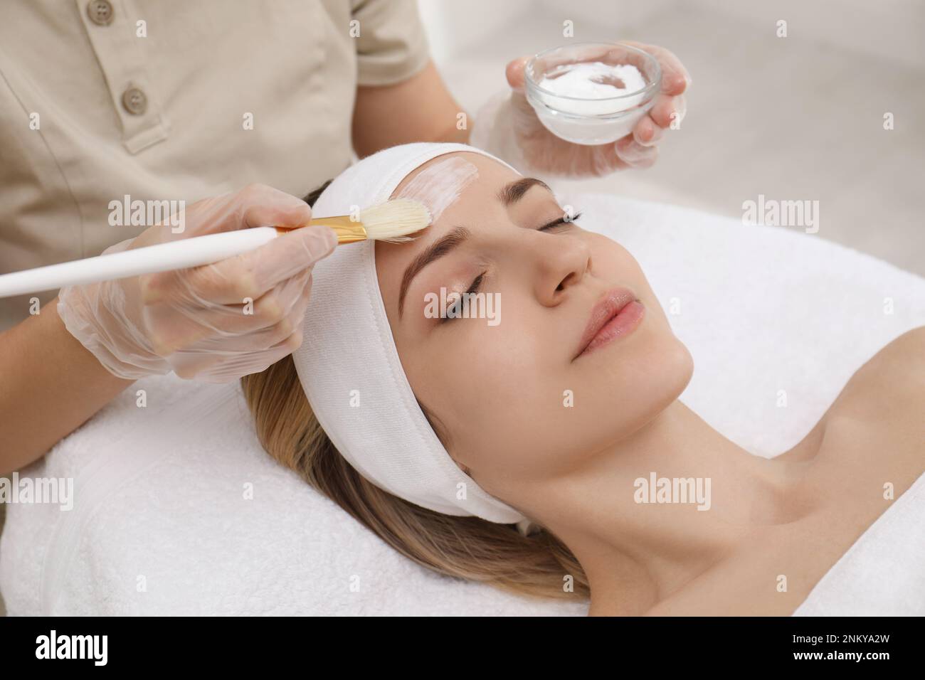Young woman during face peeling procedure in salon Stock Photo - Alamy